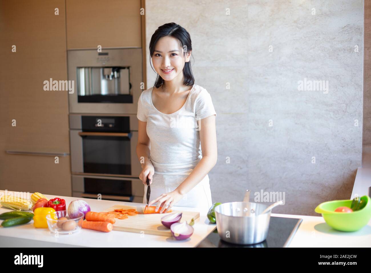 Young woman cooking in kitchen Stock Photo - Alamy