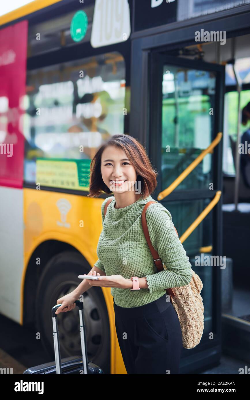 Female traveler going off the bus at terminal Stock Photo - Alamy