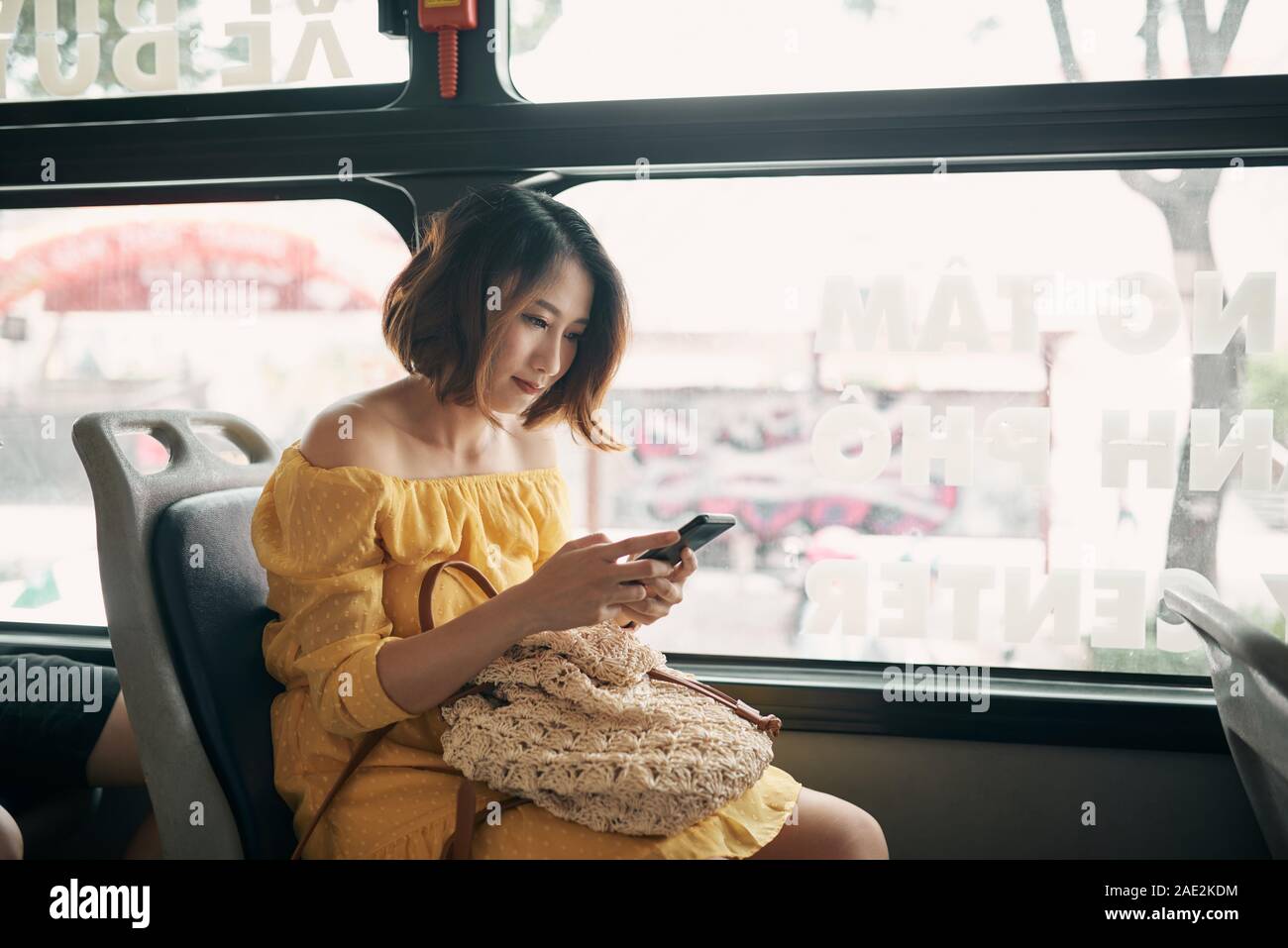 young beautiful asian woman browsing and typing messages in a public ...