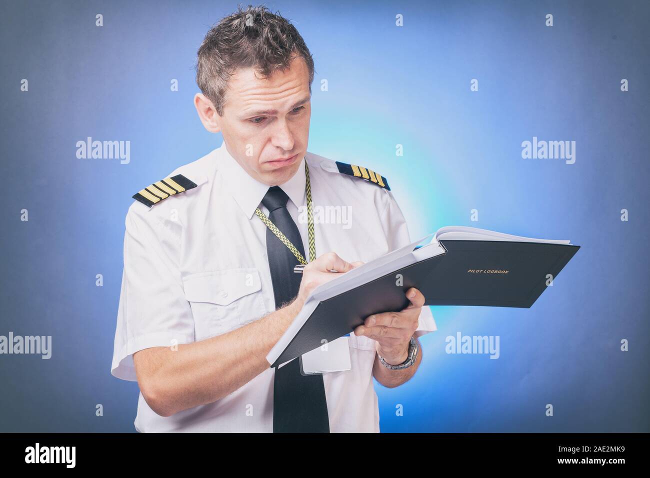 Airline pilot wearing shirt with epaulets and tie filling in filling in ...