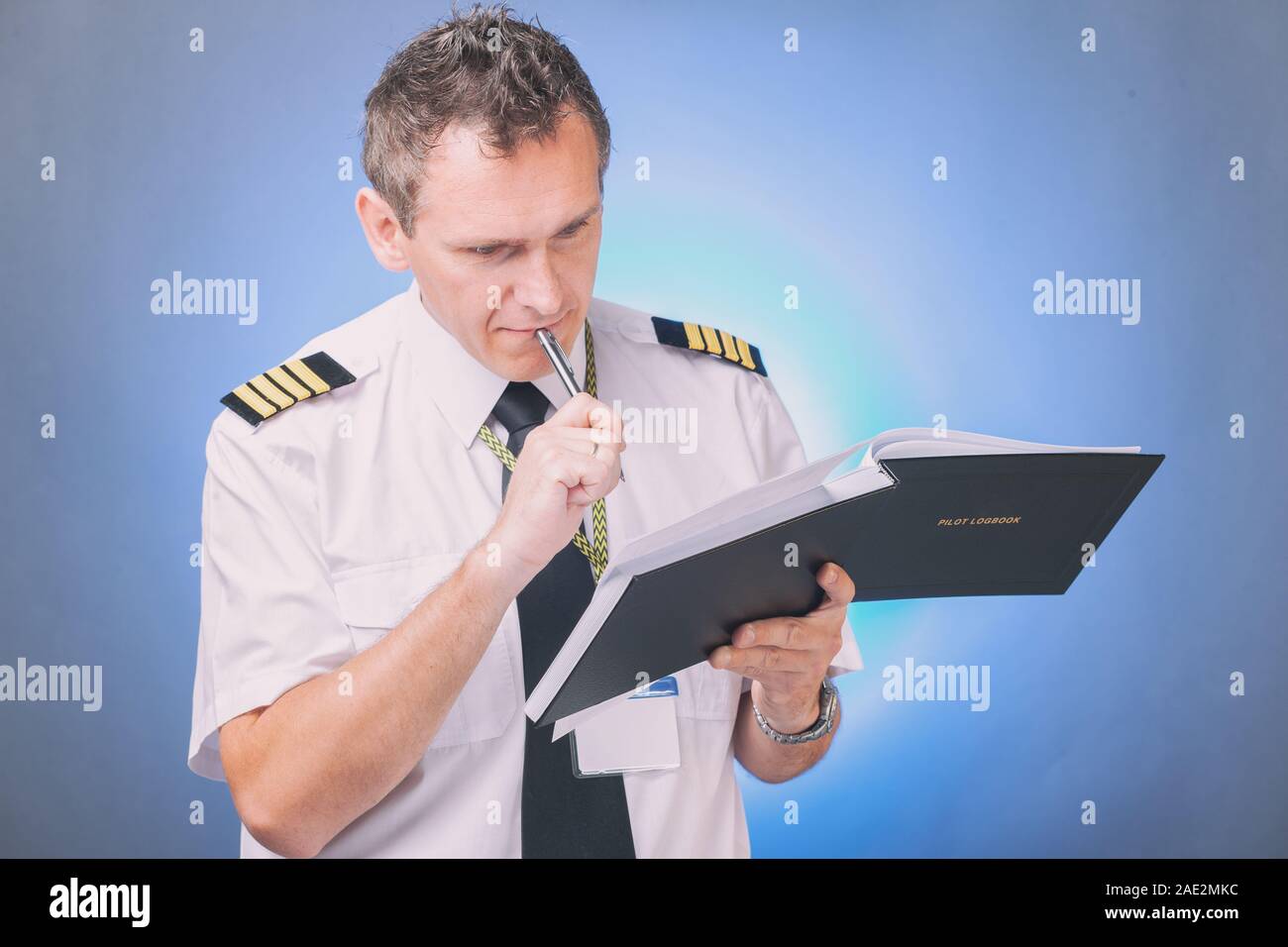 Airline pilot wearing shirt with epaulets and tie filling in filling in ...