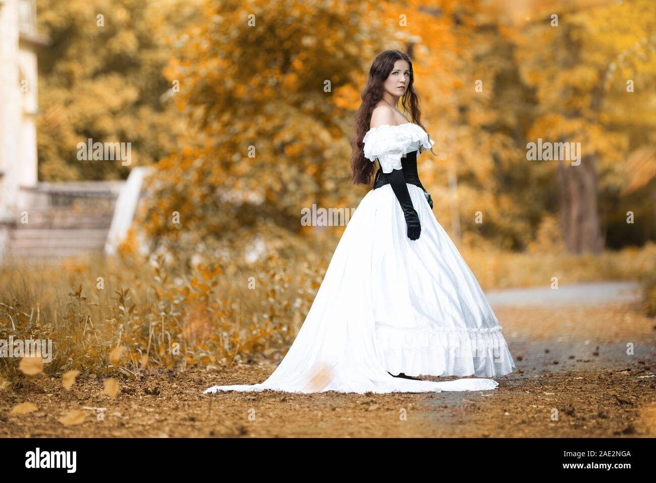 Woman in a white Victorian dress in an autumn park Stock Photo - Alamy