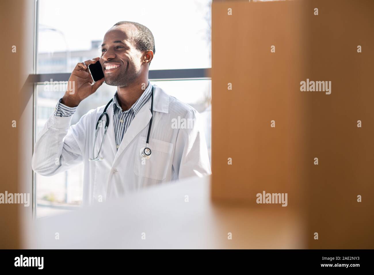Cheerful dark-skinned doctor having break Stock Photo - Alamy