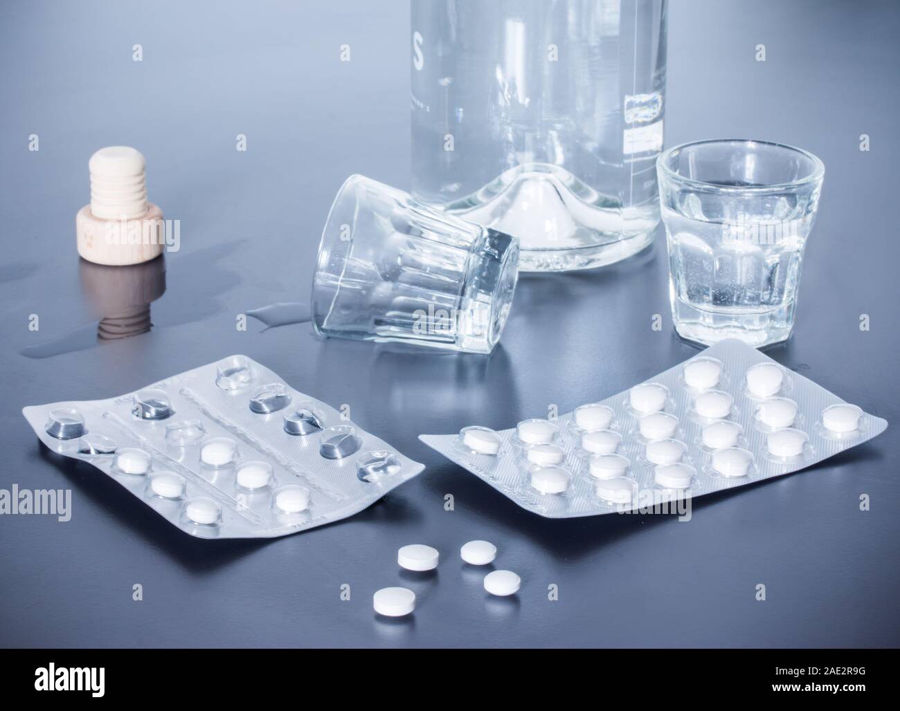 Pills and alcohol on a grey table. Concept for drug abuse Stock Photo ...