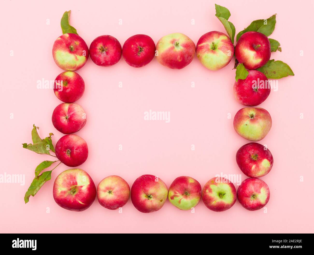 Top view on delicious red organic apples with leaves in a shape of ...