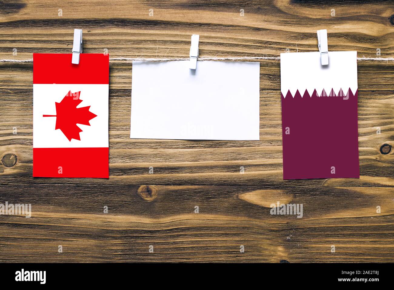 Hanging flags of Canada and Qatar attached to rope with clothes pins ...