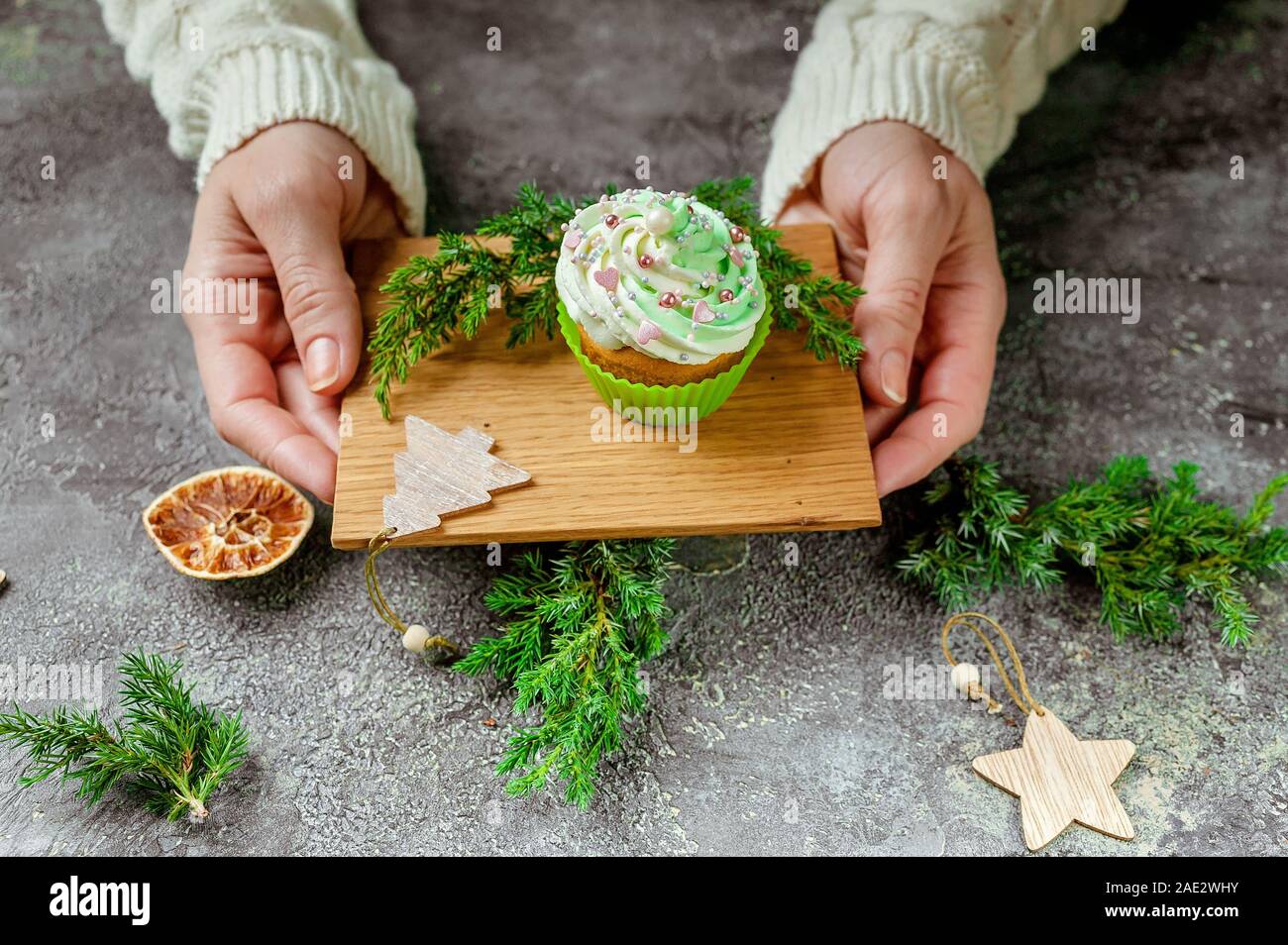 Female hands hold a homemade cream muffin. Traditional christmas ...