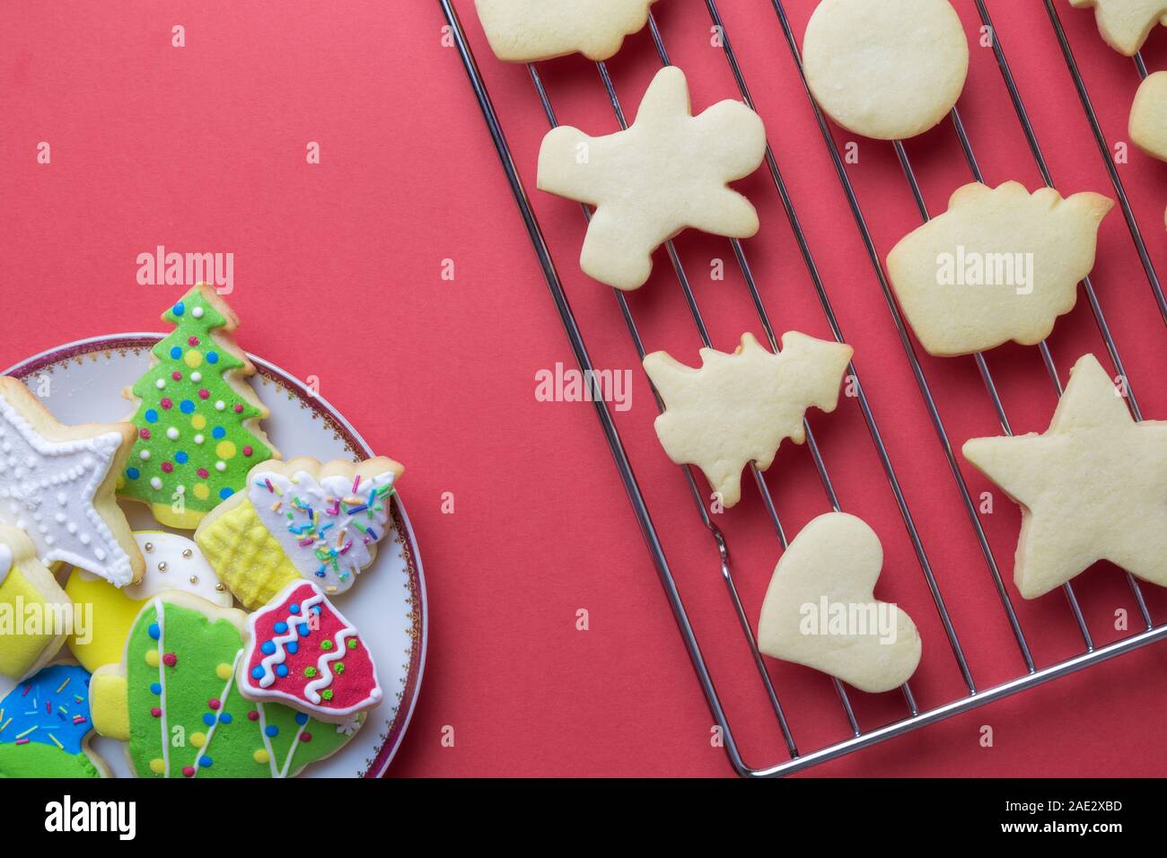 Flat lay of christmas cookies on plate and on oven grate with decorated ...