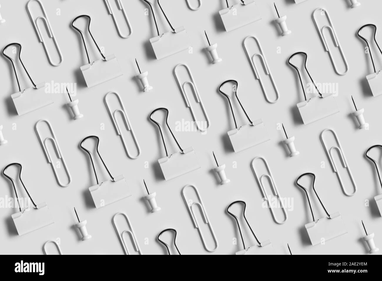 White office supplies, paper clips, pushpin and binder clips organized ...