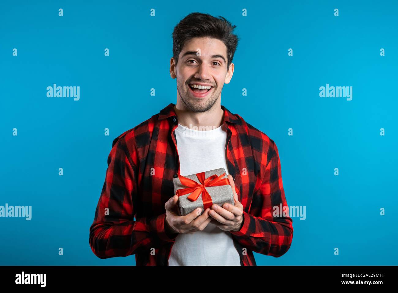 Happy european guy received present. Handsome man holding gift box on ...