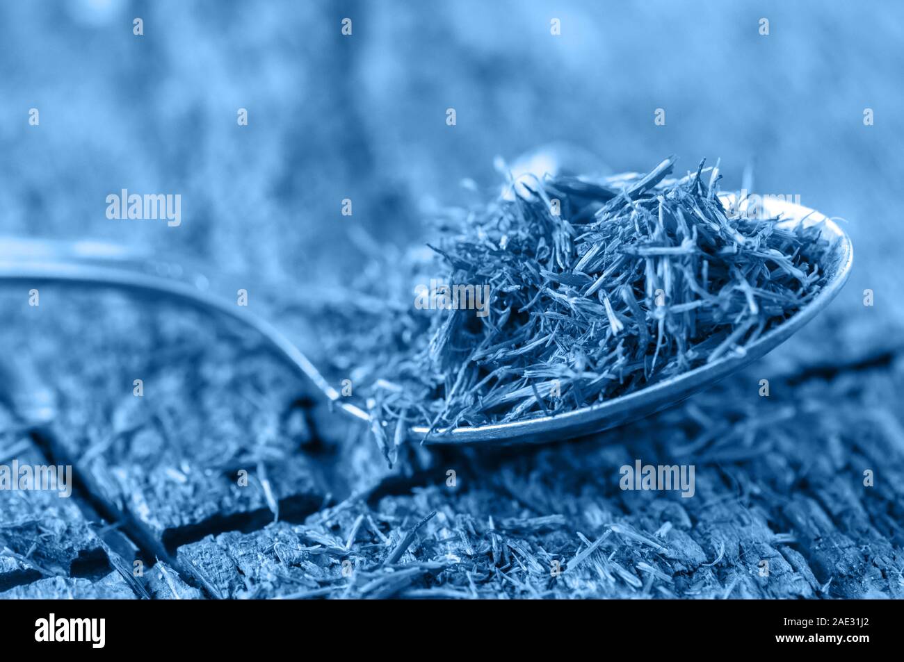 Dried saffron spice in a spoon on a wooden background. Toned Stock ...