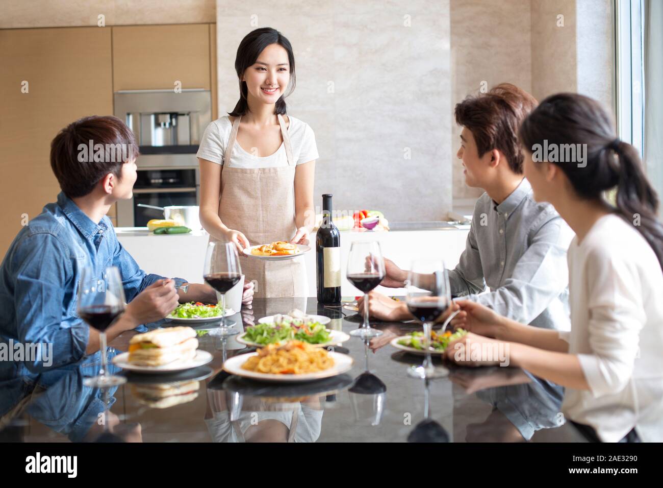 Young friends dining together at home Stock Photo - Alamy