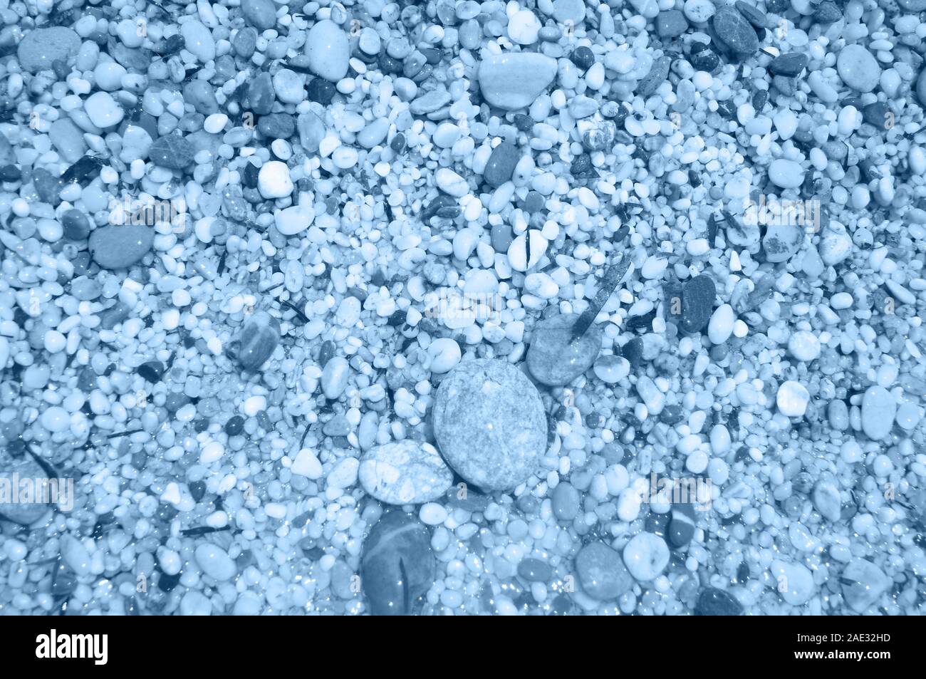 Macro close up of coarse rice-sized blue wet shiny sand grains and ...