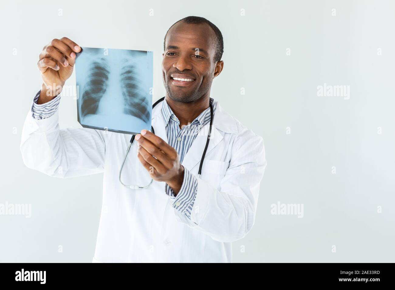 Experienced smiling doctor holding x-ray scan Stock Photo - Alamy