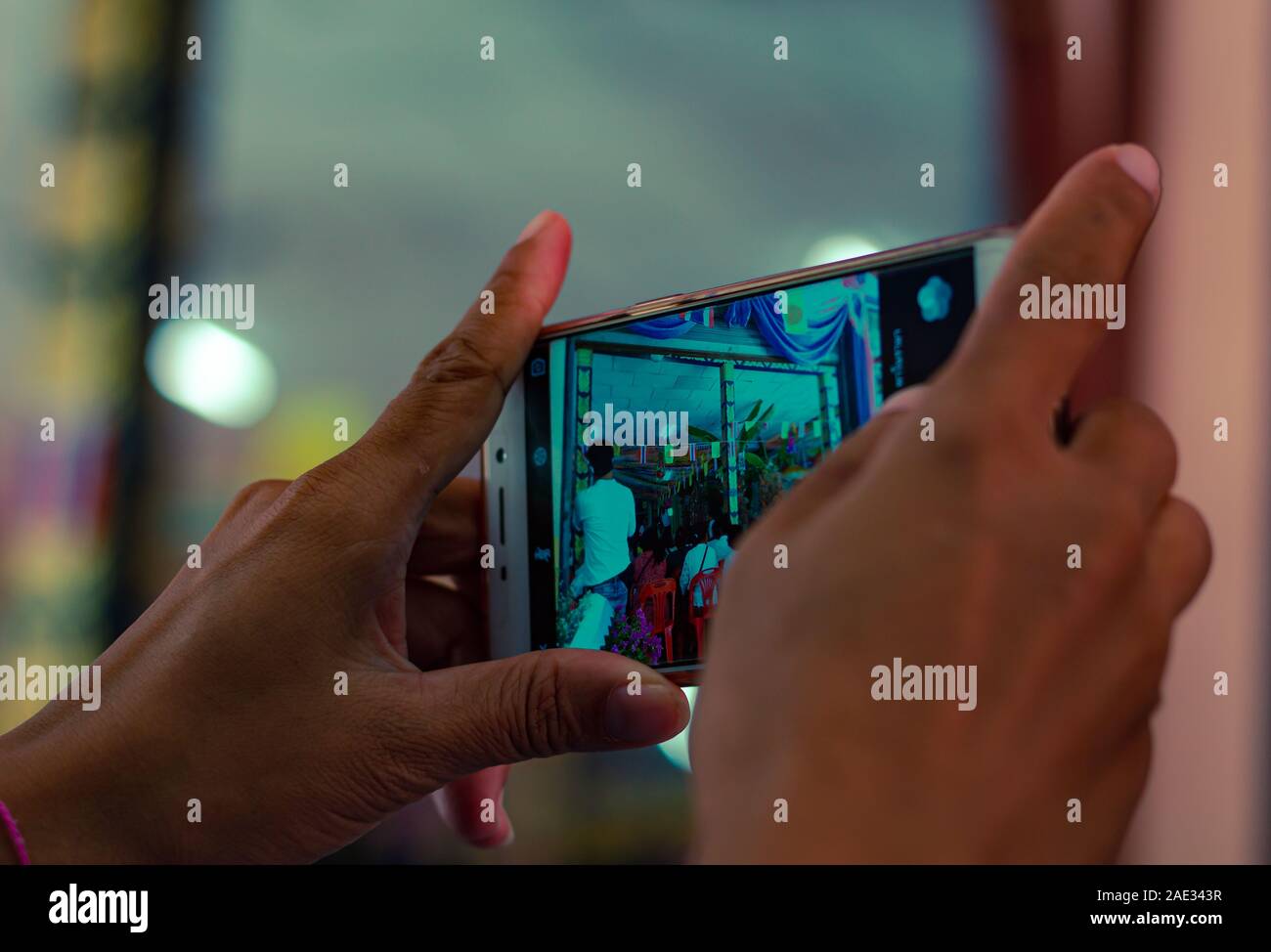 A woman's hand holding a mobile phone to take a photo of an event ...
