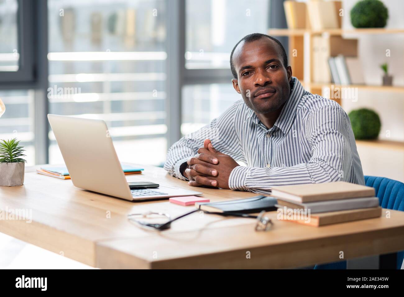 Serious manager looking straight at camera Stock Photo - Alamy