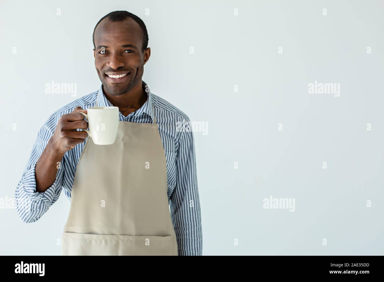 Positive cafe owner drinking coffee Stock Photo - Alamy