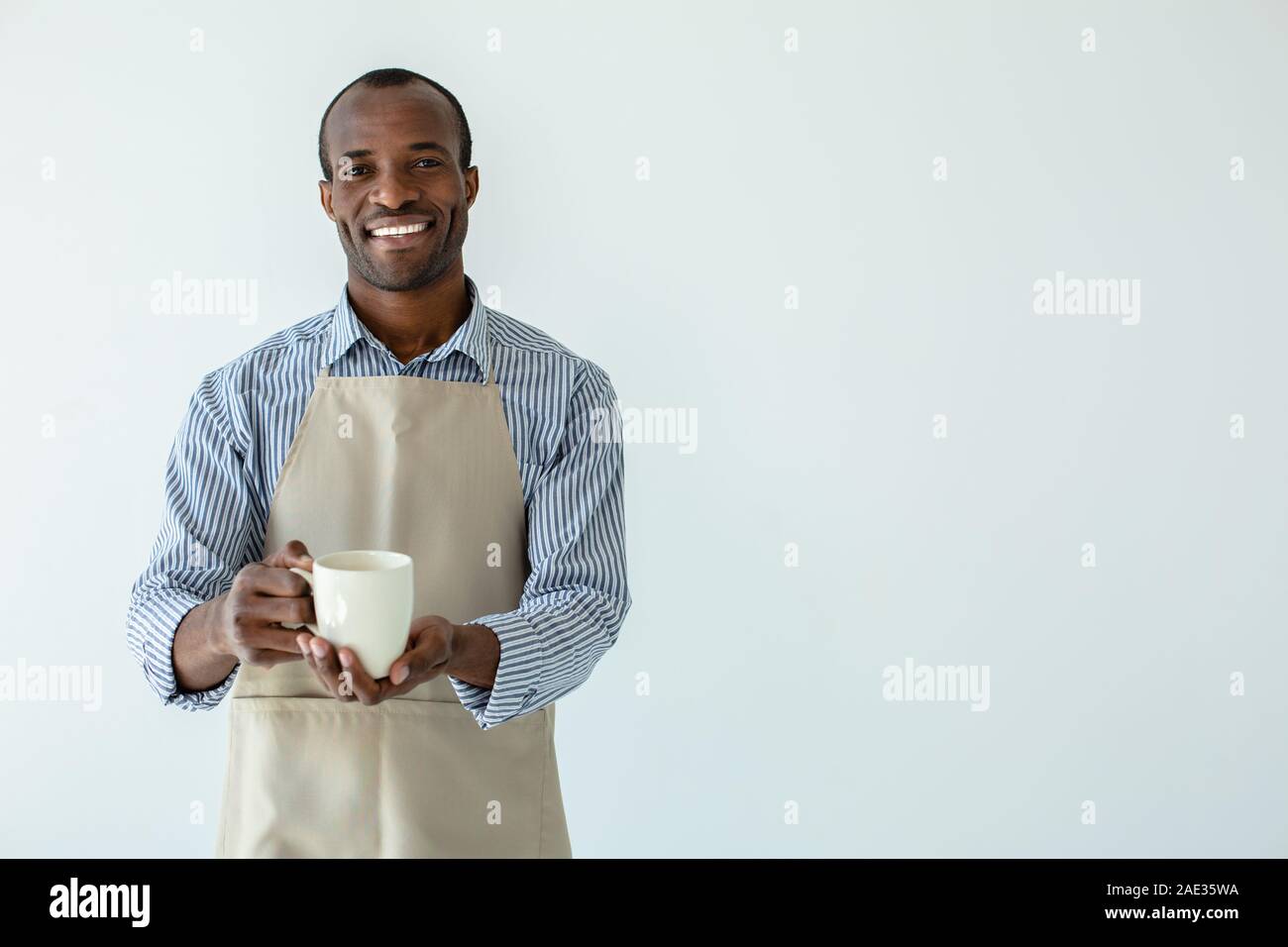 Positive barista drinking coffee Stock Photo - Alamy
