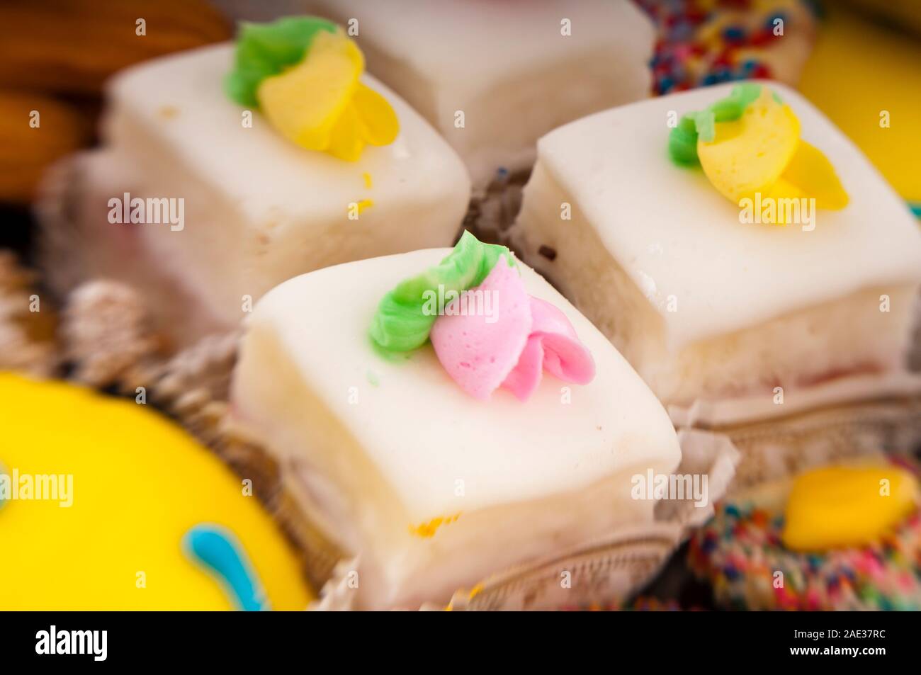 Bakery display closeup of iced petit fours small cakes Stock Photo - Alamy