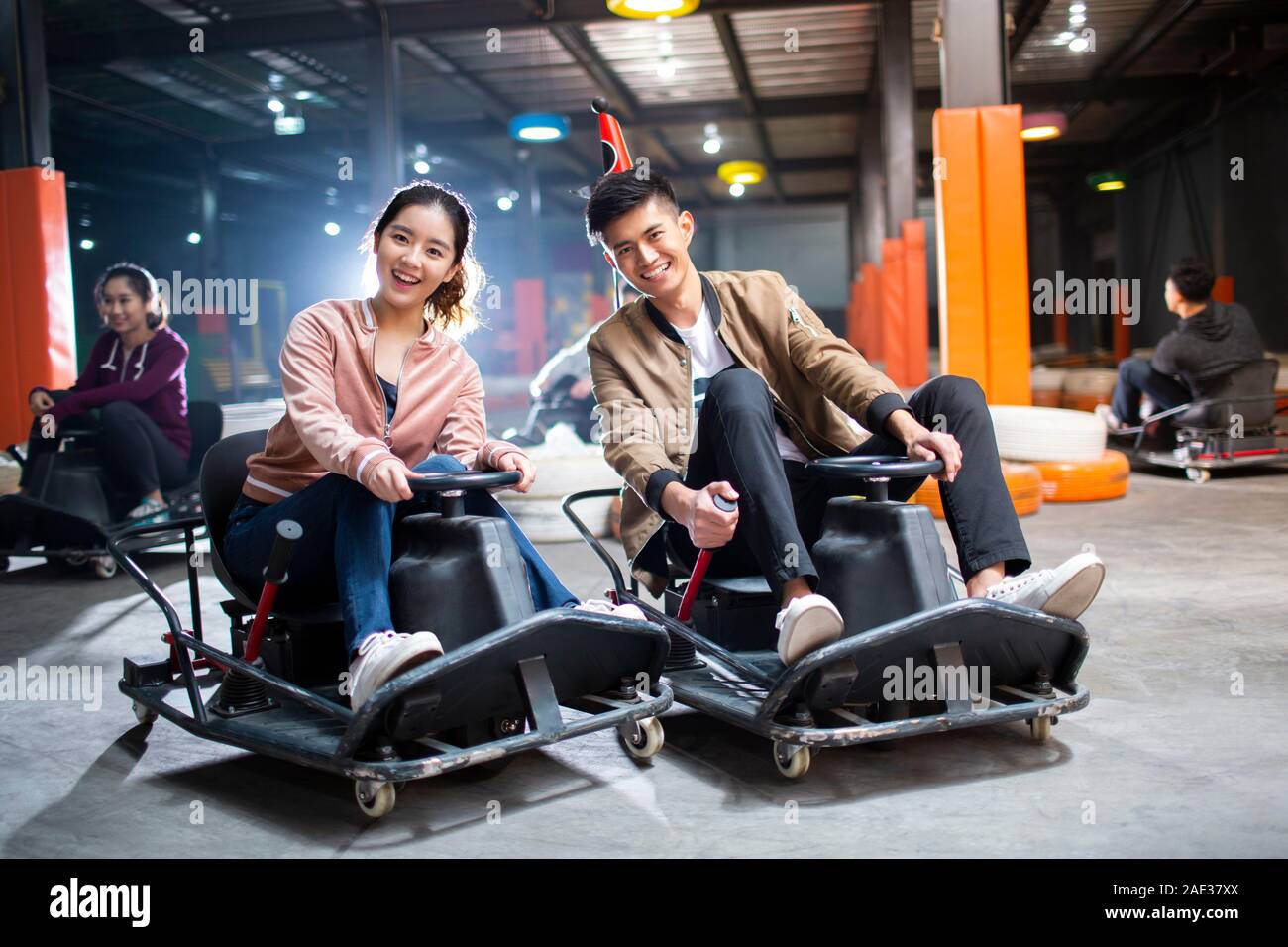 Happy young friends driving go-carts Stock Photo - Alamy