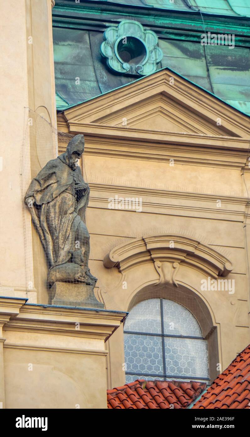 Stone statue on facade of Church of Saint Nicholas in Old Town Square ...