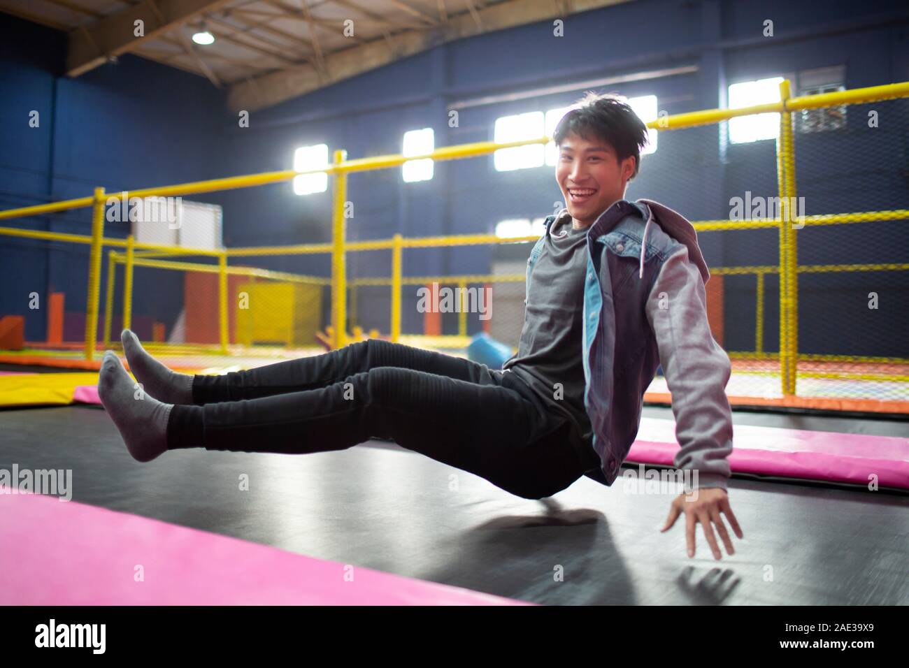 Happy young man jumping on trampoline Stock Photo - Alamy