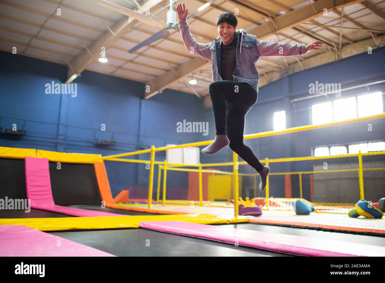 Happy young man jumping on trampoline Stock Photo - Alamy