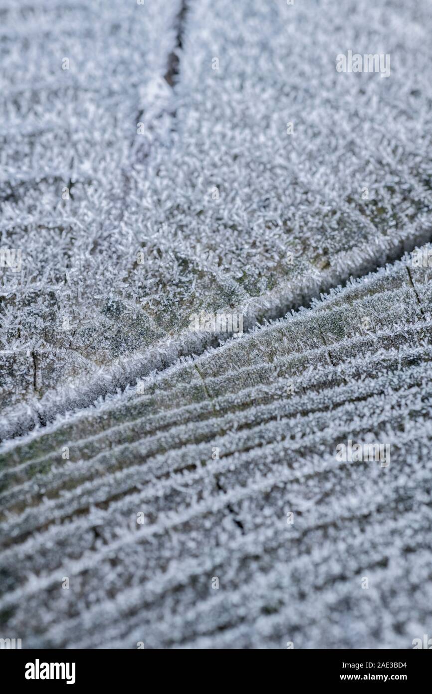 Sharp frosty ice crystals forming on a fencing post. Winter season ...