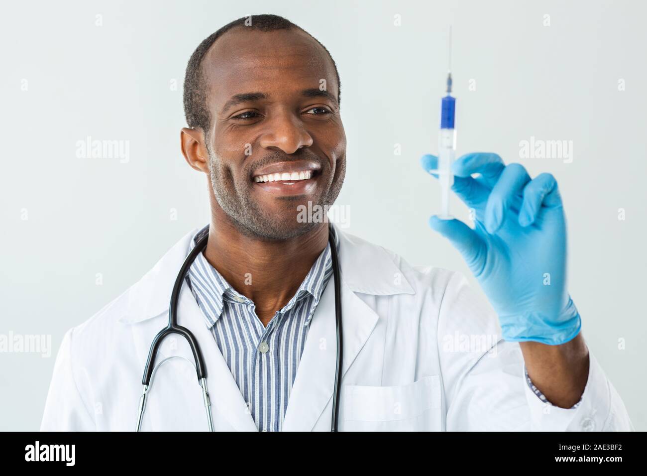 Professional smiling practitioner holding a syringe Stock Photo - Alamy