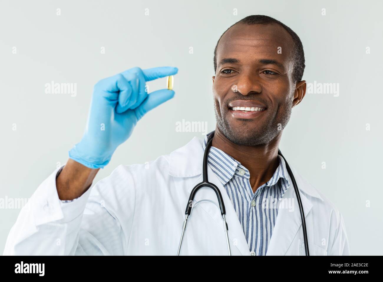 Joyful professional doctor holding helpful remedy Stock Photo - Alamy