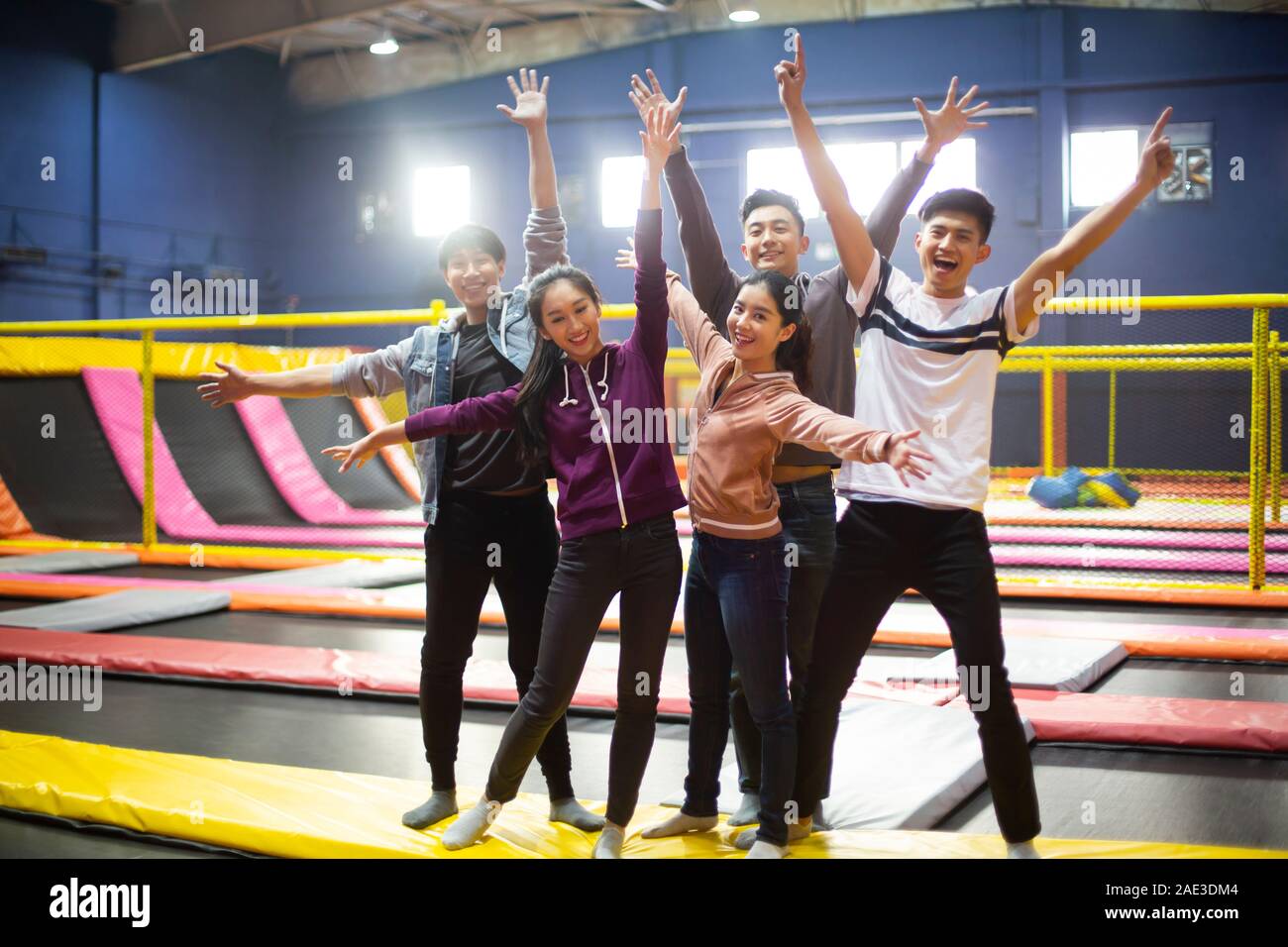 Happy young friends jumping on trampoline Stock Photo - Alamy