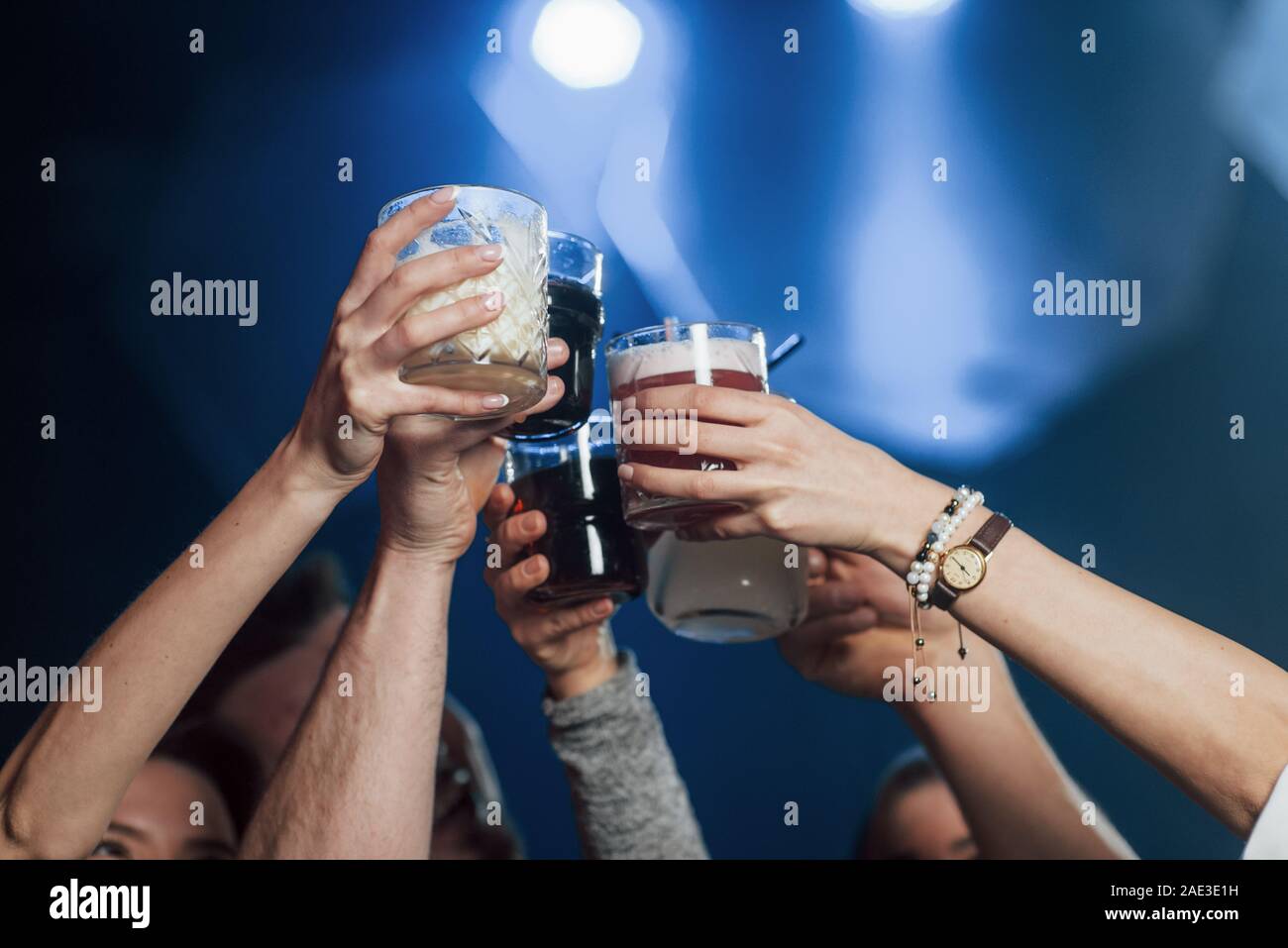 Variety of drinks. Group of young friends smiling and making a toast in ...