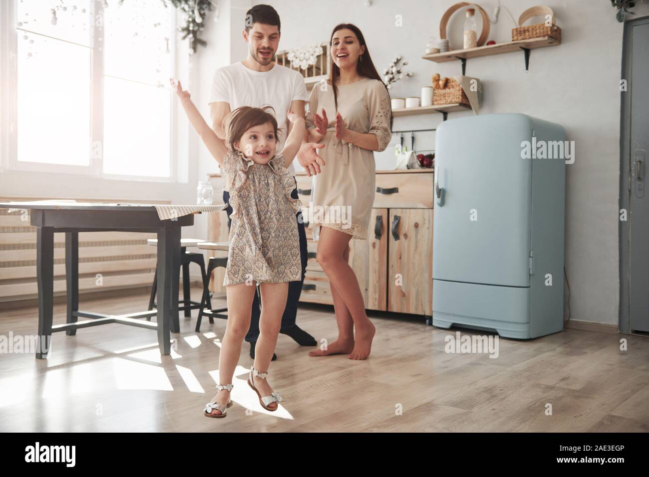 With hands up. Playful female child have fun by running in the kitchen ...