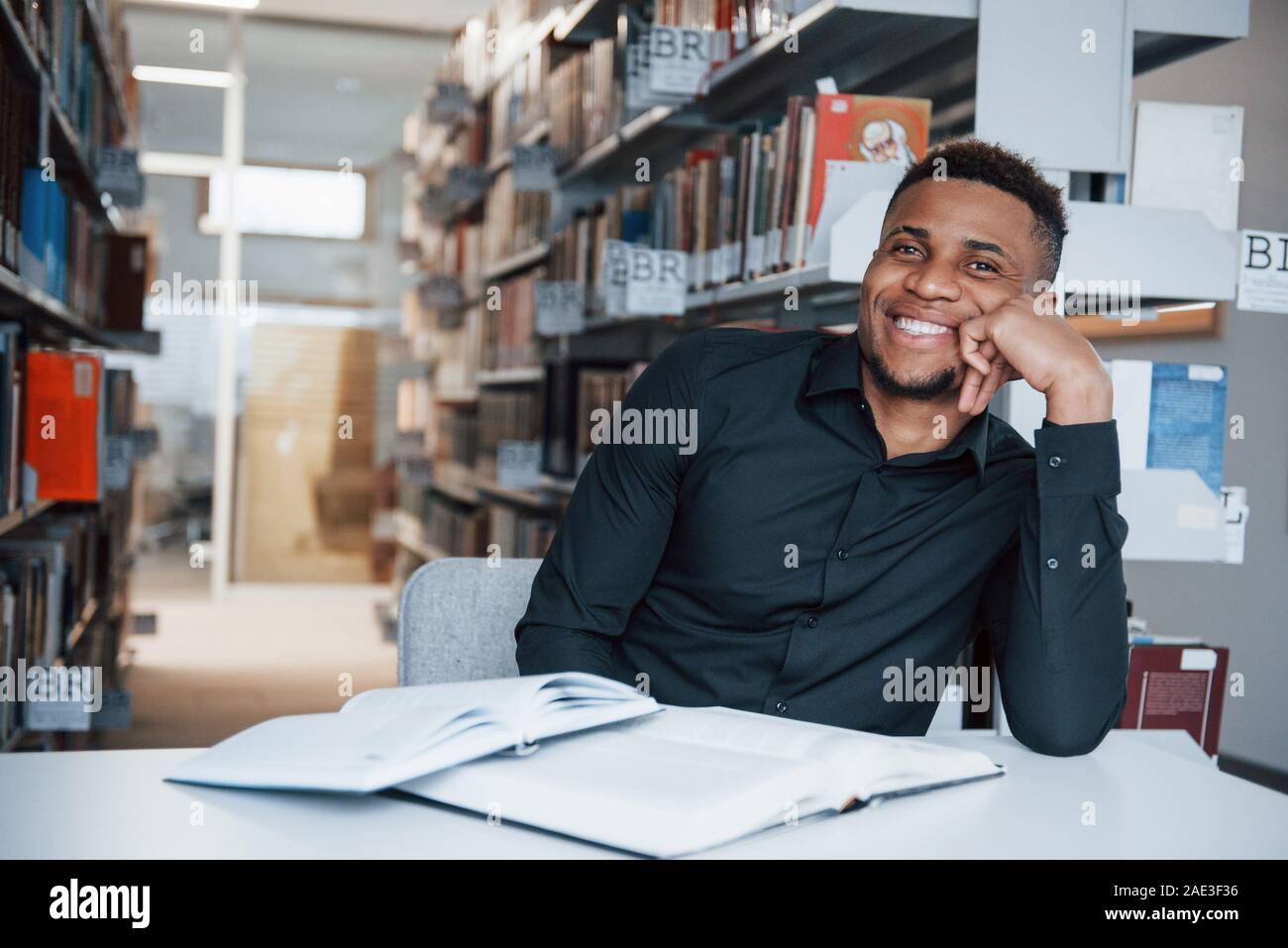 Time for the rest. African american man sitting in the library and ...