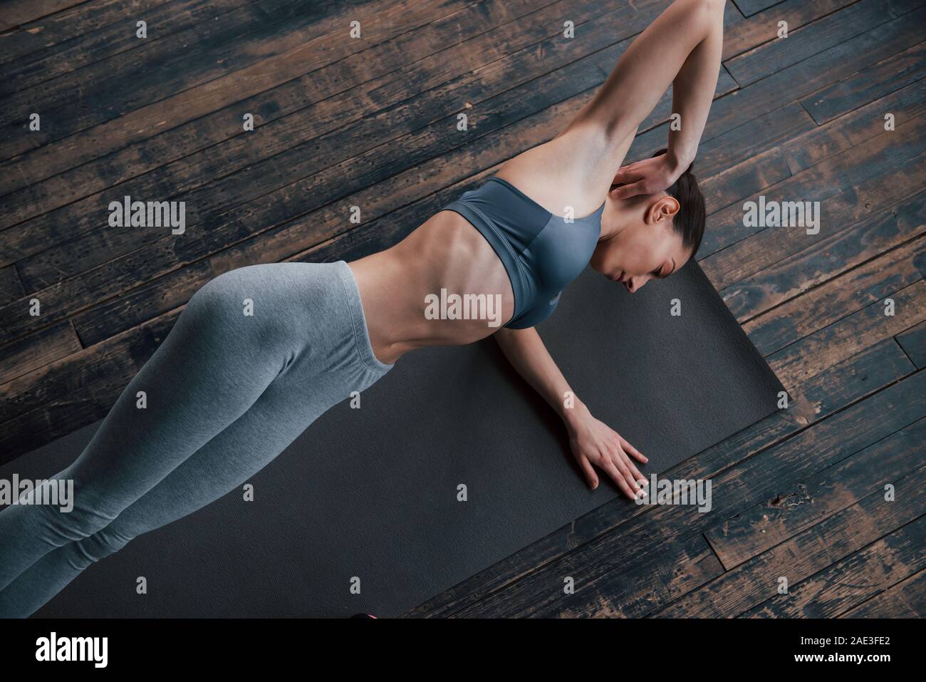 On the side. Top view of girl with slender body works on the abs when ...