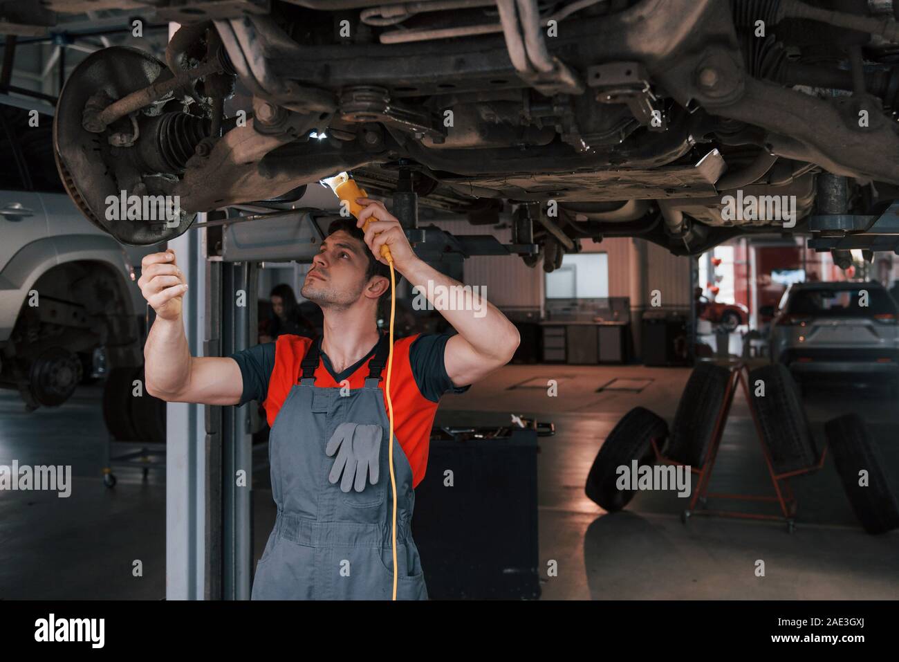 Ready for replacement. Man at the workshop in uniform fixes broken ...