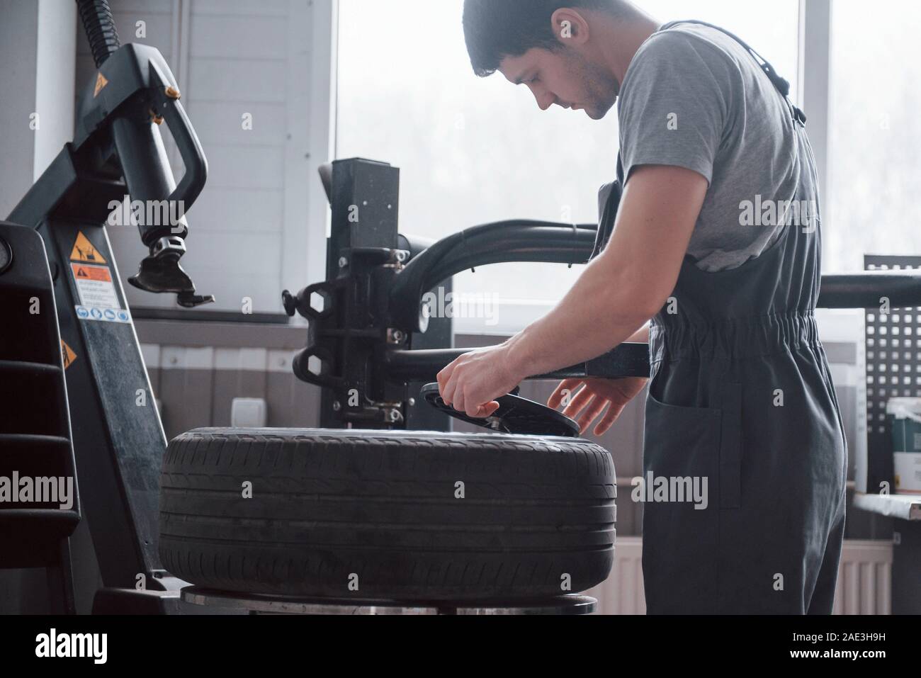 Item in hands. Young man works with wheel's disks at the workshop at ...