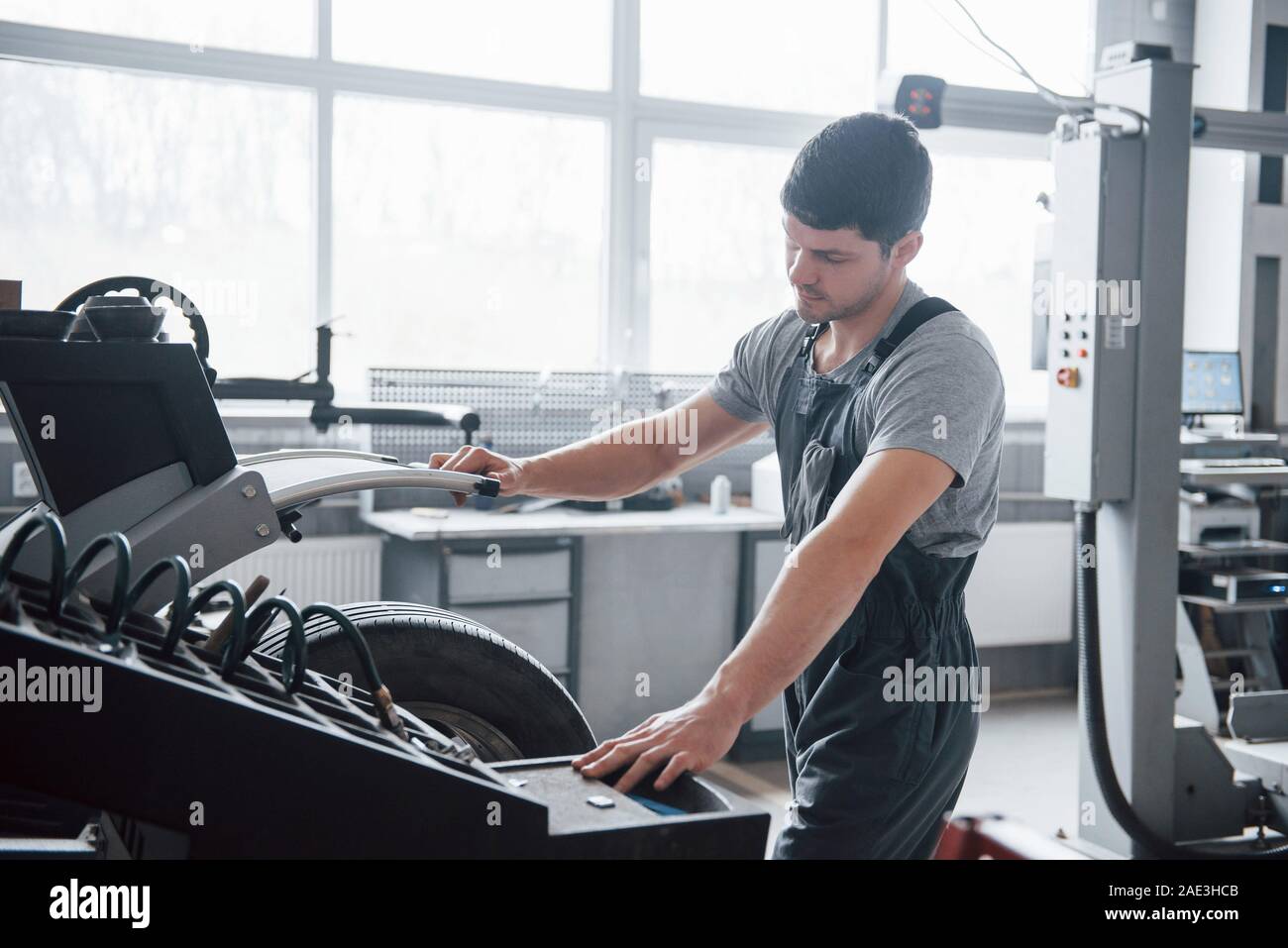 Machine doing the job. Young man works with wheel's disks at the ...