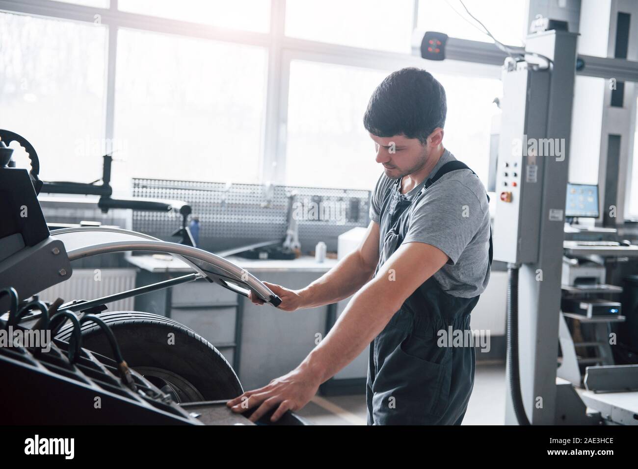Let this machine do the job. Young man works with wheel's disks at the ...