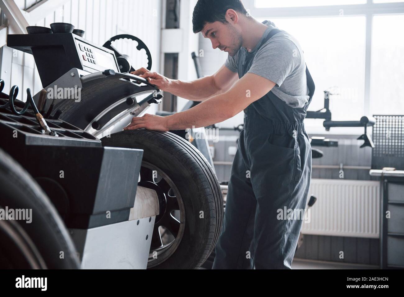 Technologies make it easier. Young man works with wheel's disks at the ...