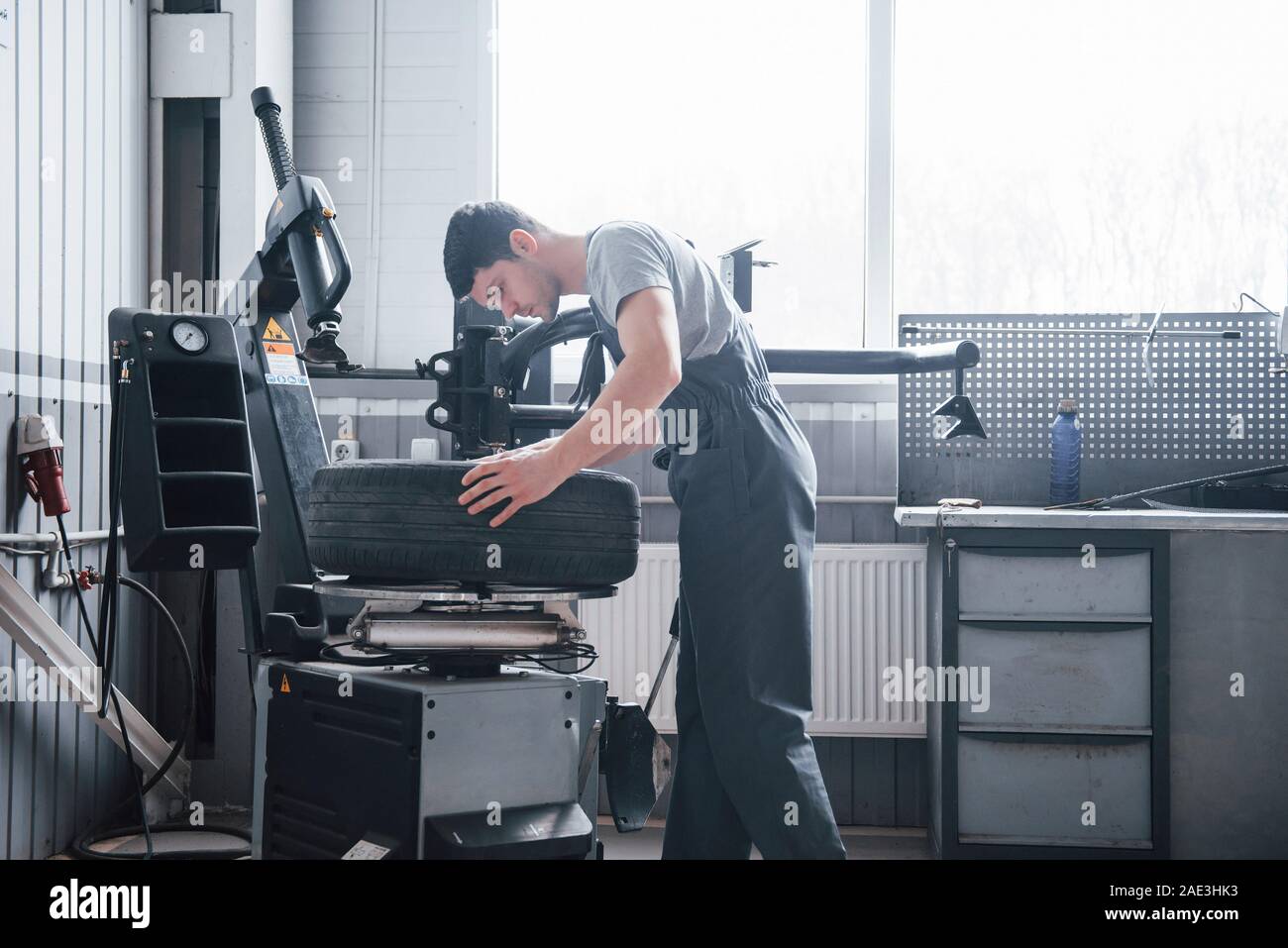 Wheel is in horizontal position. Young man works with wheel's disks at ...
