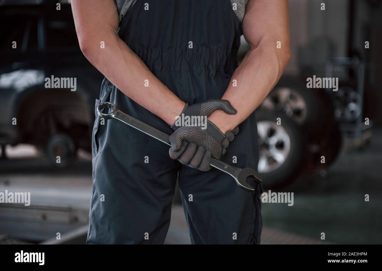Mechanic looks forward. Rear view of worker in uniform that stands in ...