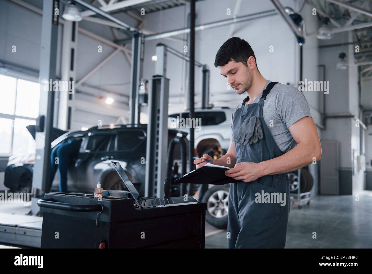 Looks not bad. Worker stands indoors in uniform does reports ...