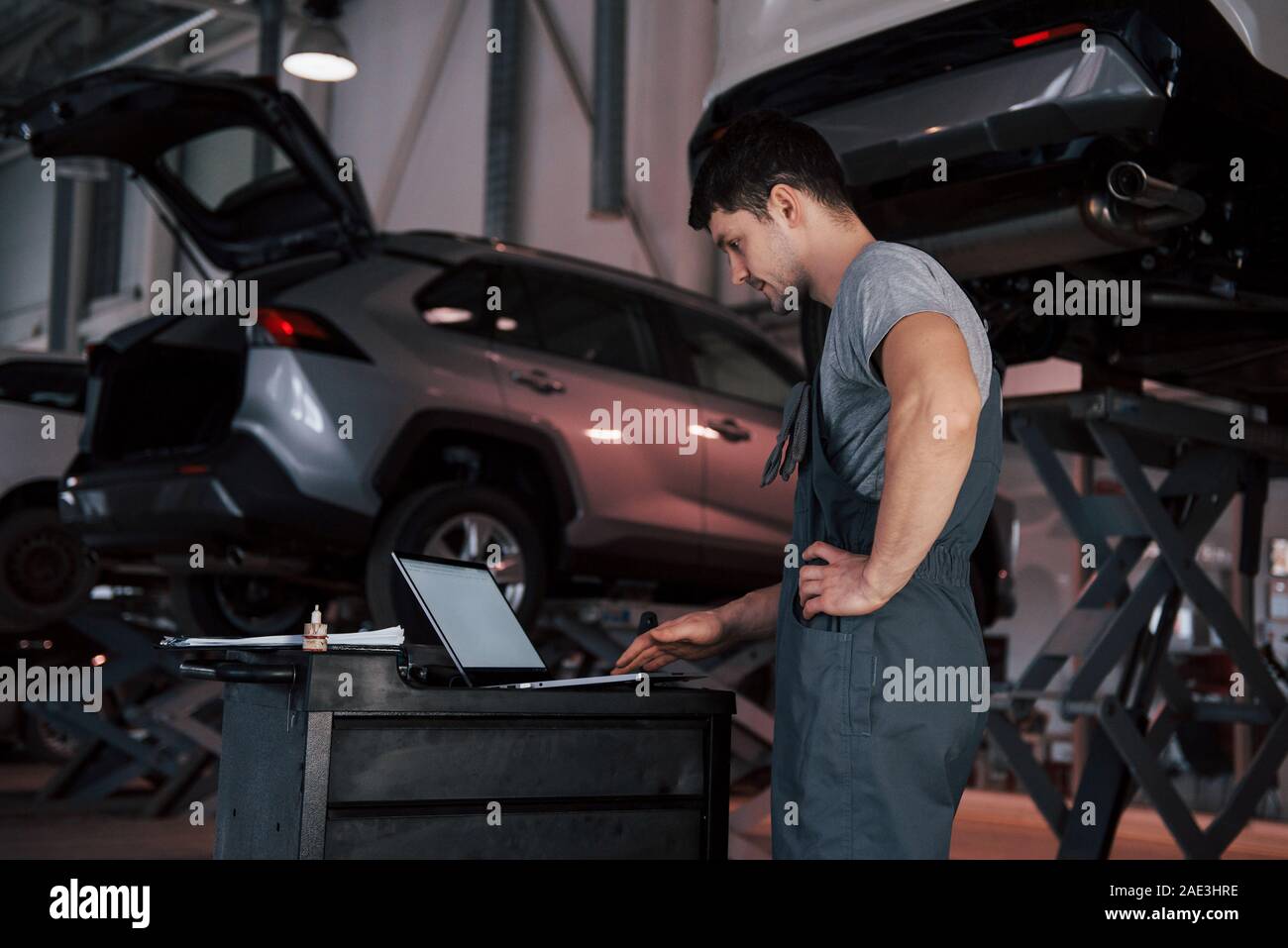 Internet for shopping items. Worker stands indoors in uniform does ...