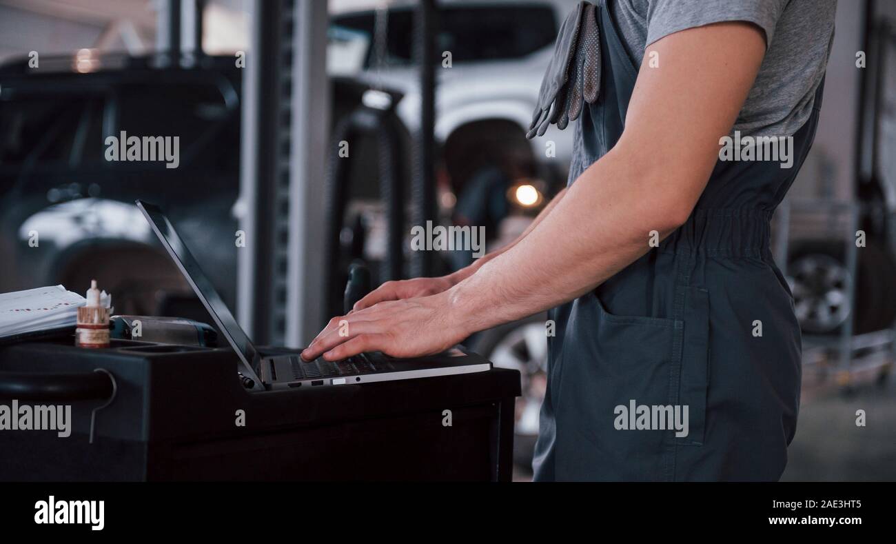 Typing a text. Worker stands indoors in uniform does reports ...