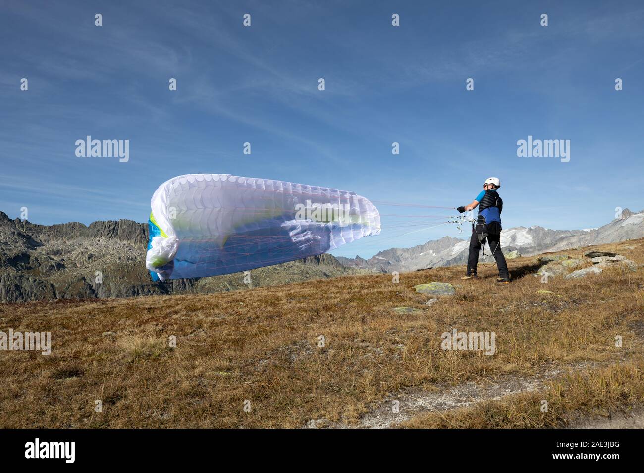 Young paraglider pilot exercises with his paraglider pulling up in the ...