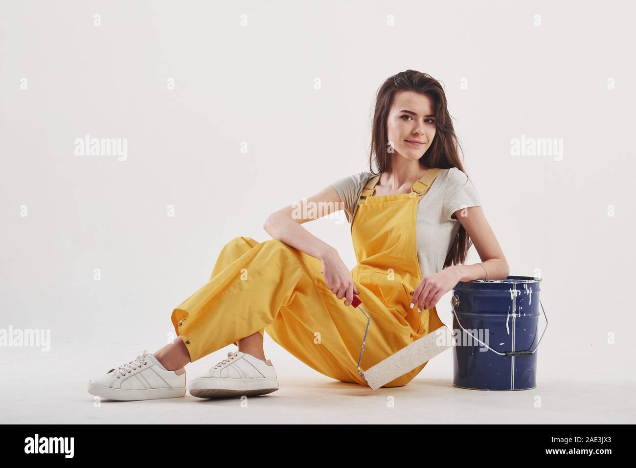 Ready for the work. Brunette woman in yellow uniform sitting against ...