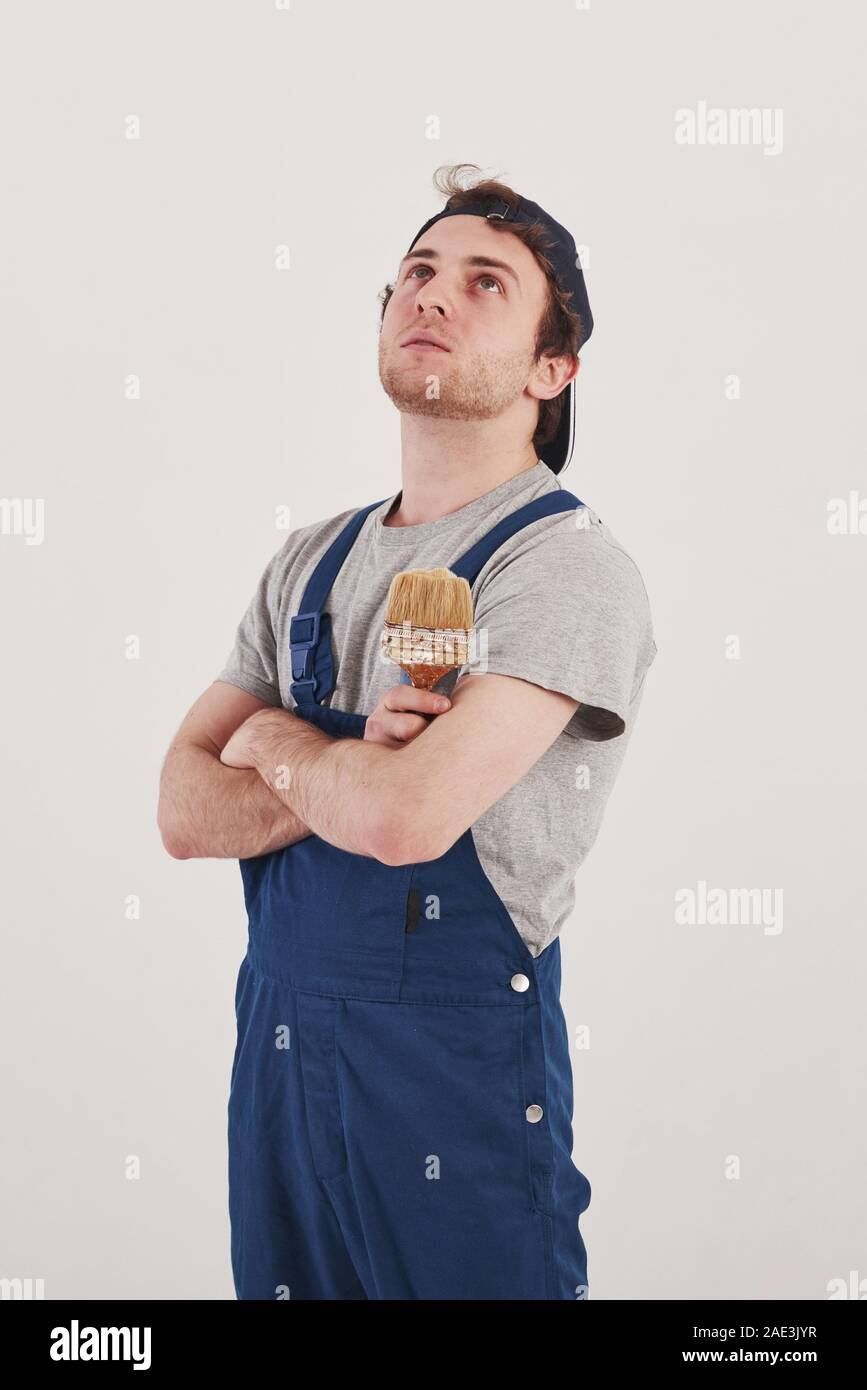 Unshaved guy. Man in blue uniform stands against white background in ...