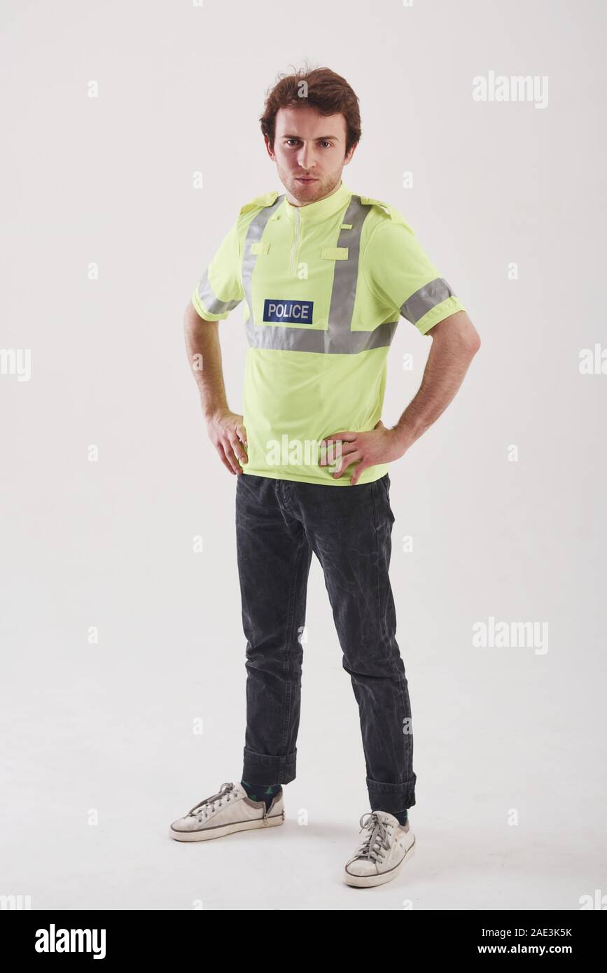 Policeman in green uniform stands against white background in the ...