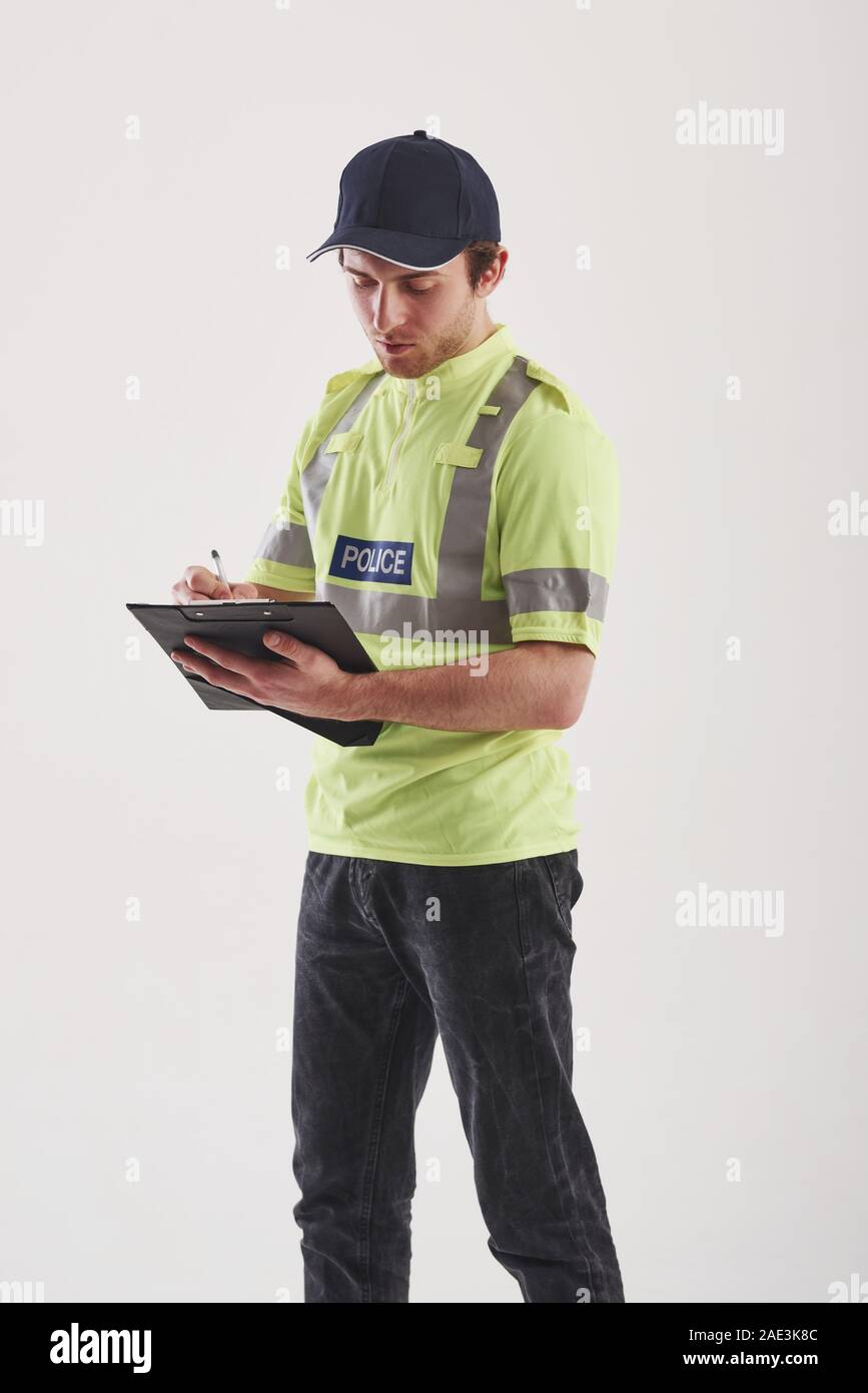 Working on the new task. Policeman in green uniform stands against ...